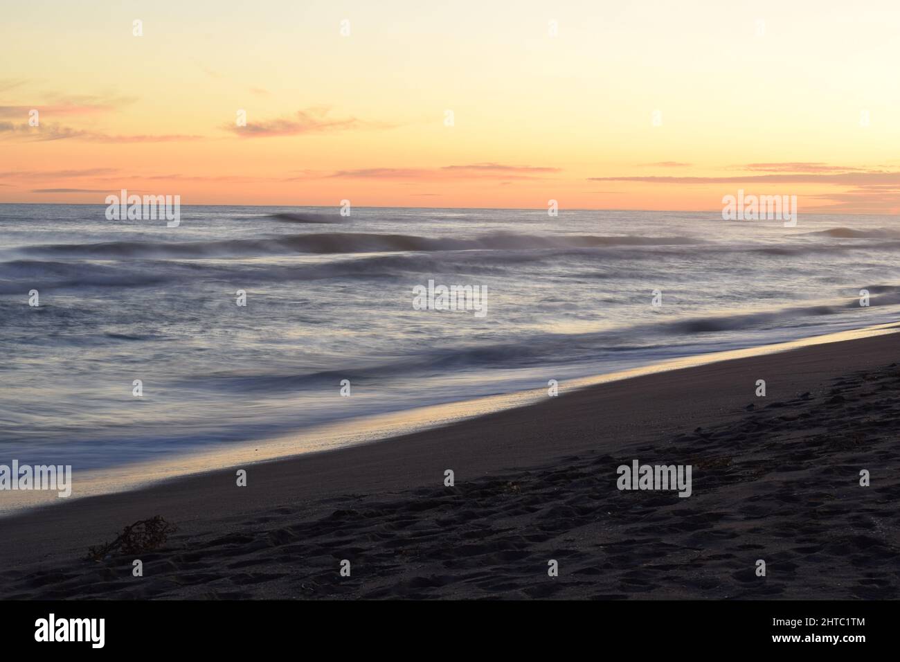 Sandy beach, calm sea and a beautiful sunset on the background Stock ...