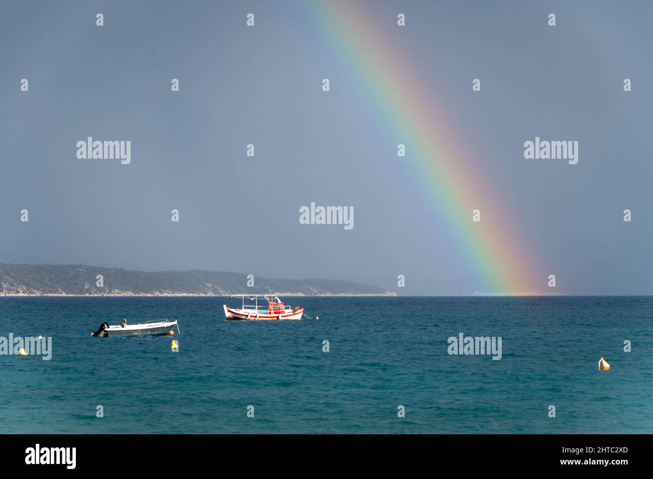 Rainbow and fishing boats at sea. The photo was shot on a cloudy day ...