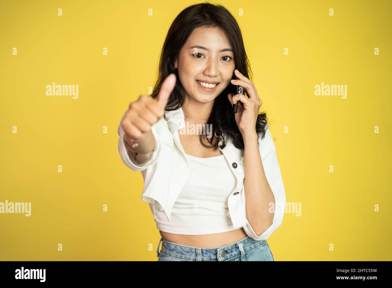 woman making a call using a mobile phone with thumbs up Stock Photo - Alamy
