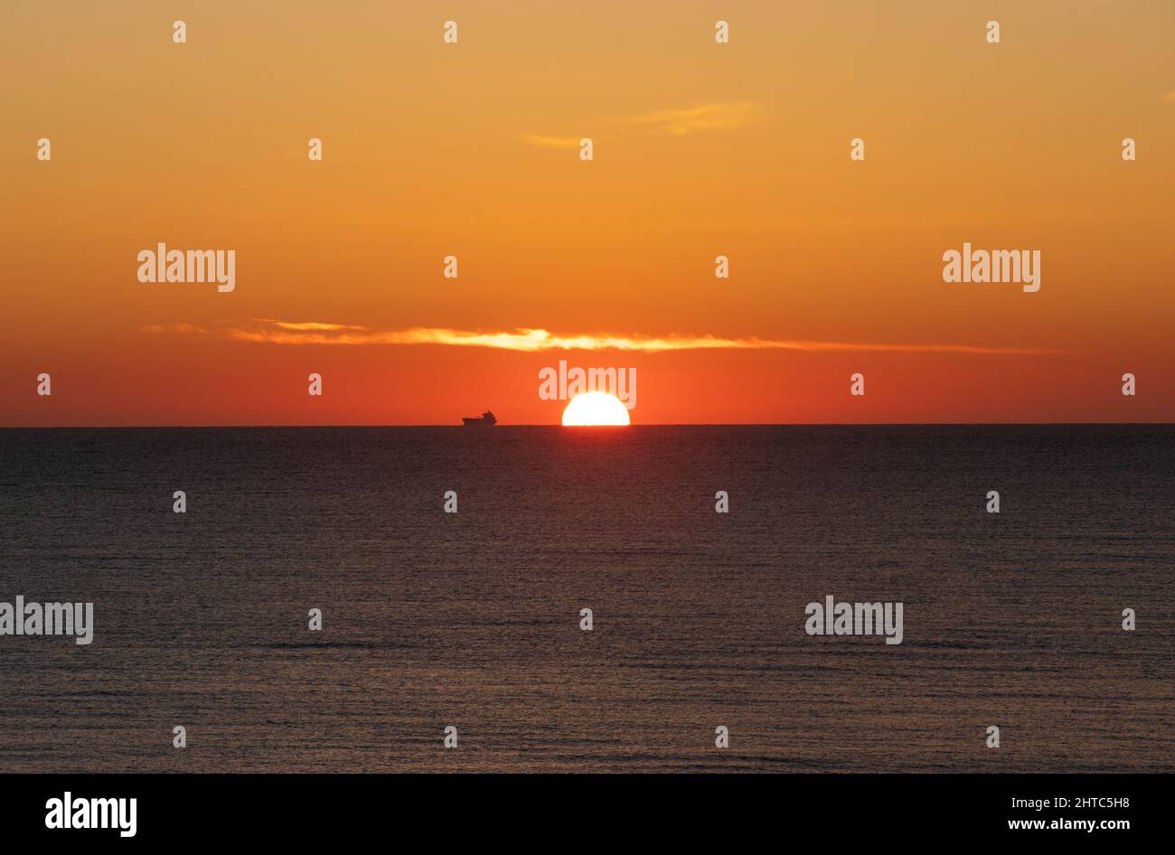 Landscape with a ship near the sun rising from the sea Stock Photo - Alamy