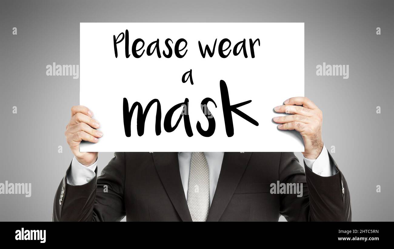 Business man holding a paper in front of his face with the message ...
