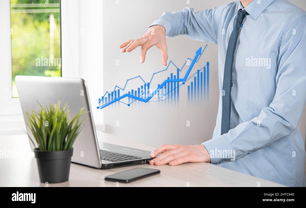 Business man holding tablet and showing holographic graphs and stock ...