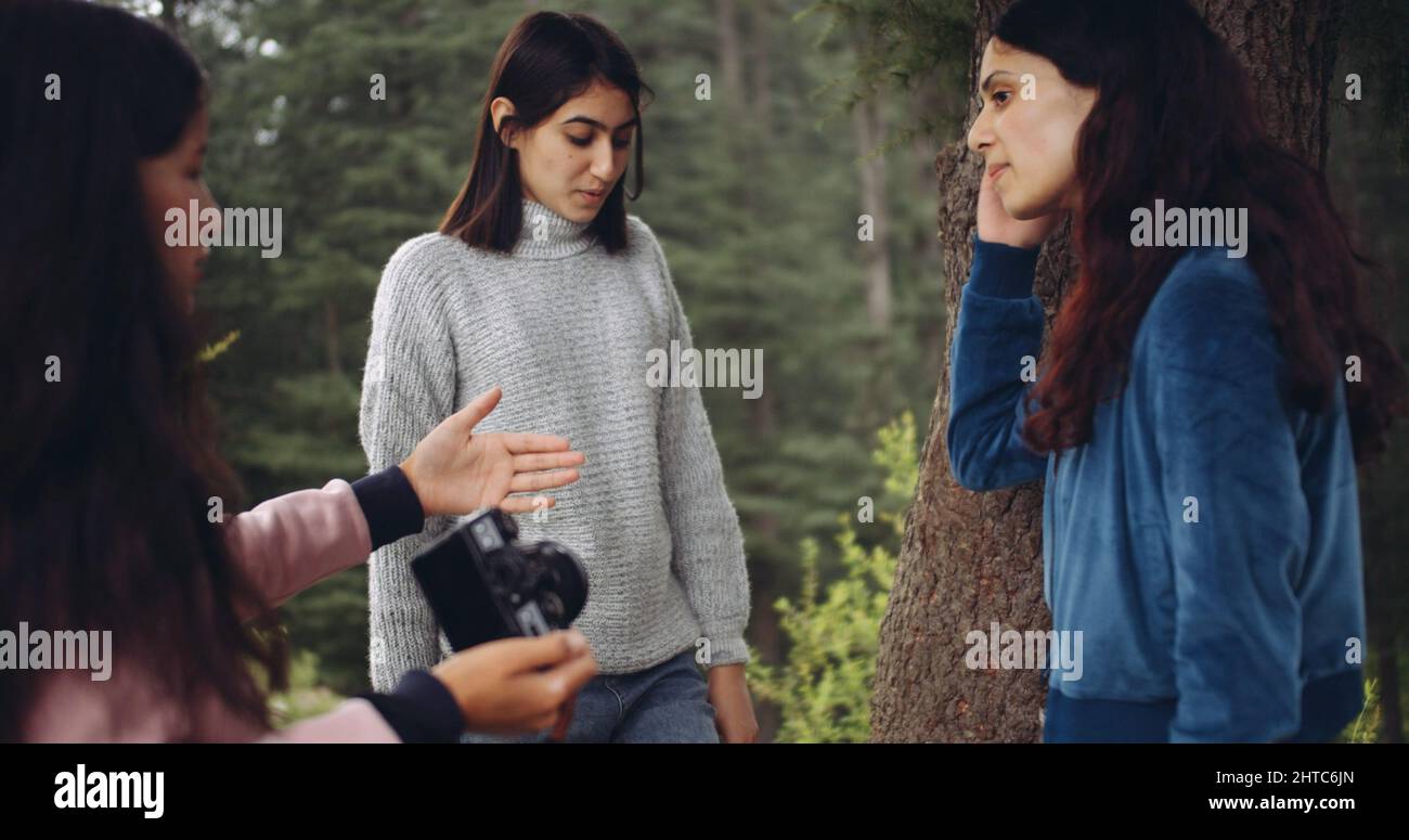 Group of female young South Asian friends with a camera talking in a ...