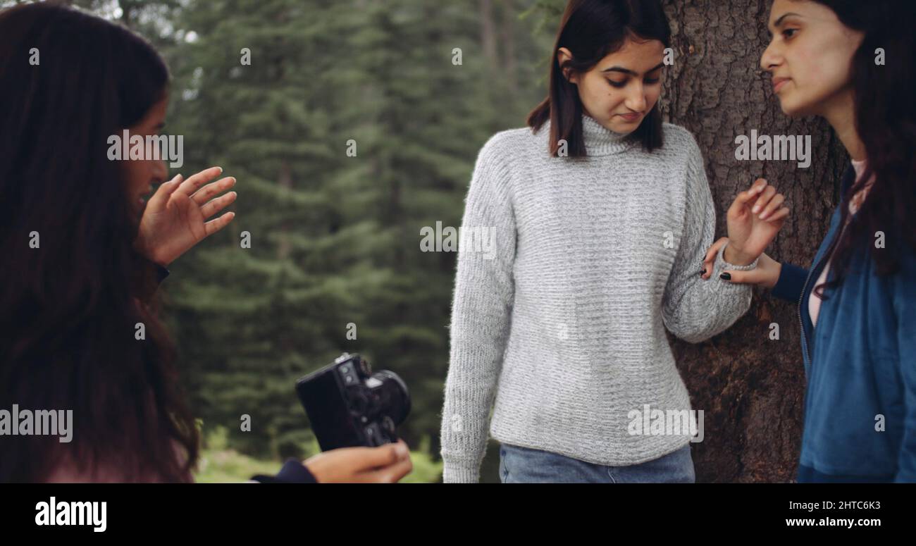 Group of young female South Asian friends with a camera talking near a ...