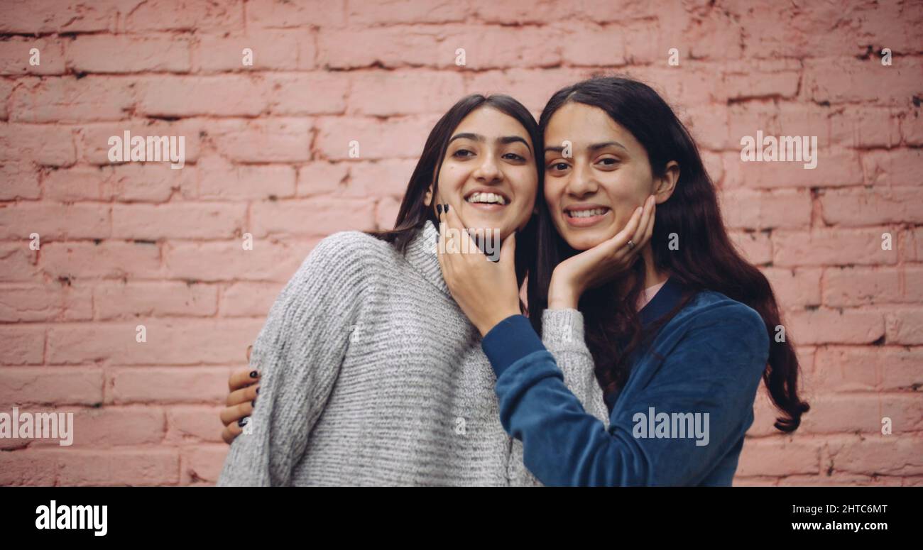View of happy friends on the brick wall background smiling at the ...
