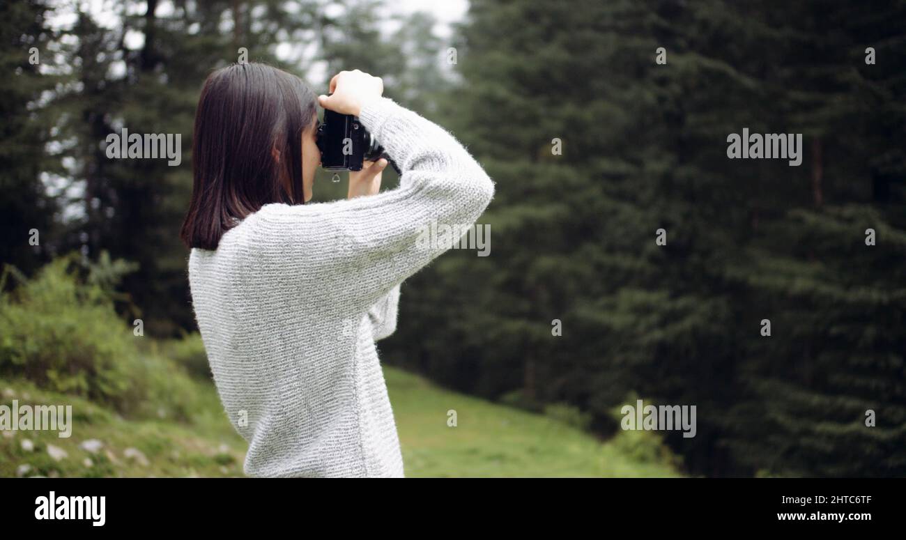 Young smiling South Asian girl taking a photo in the woods in India ...
