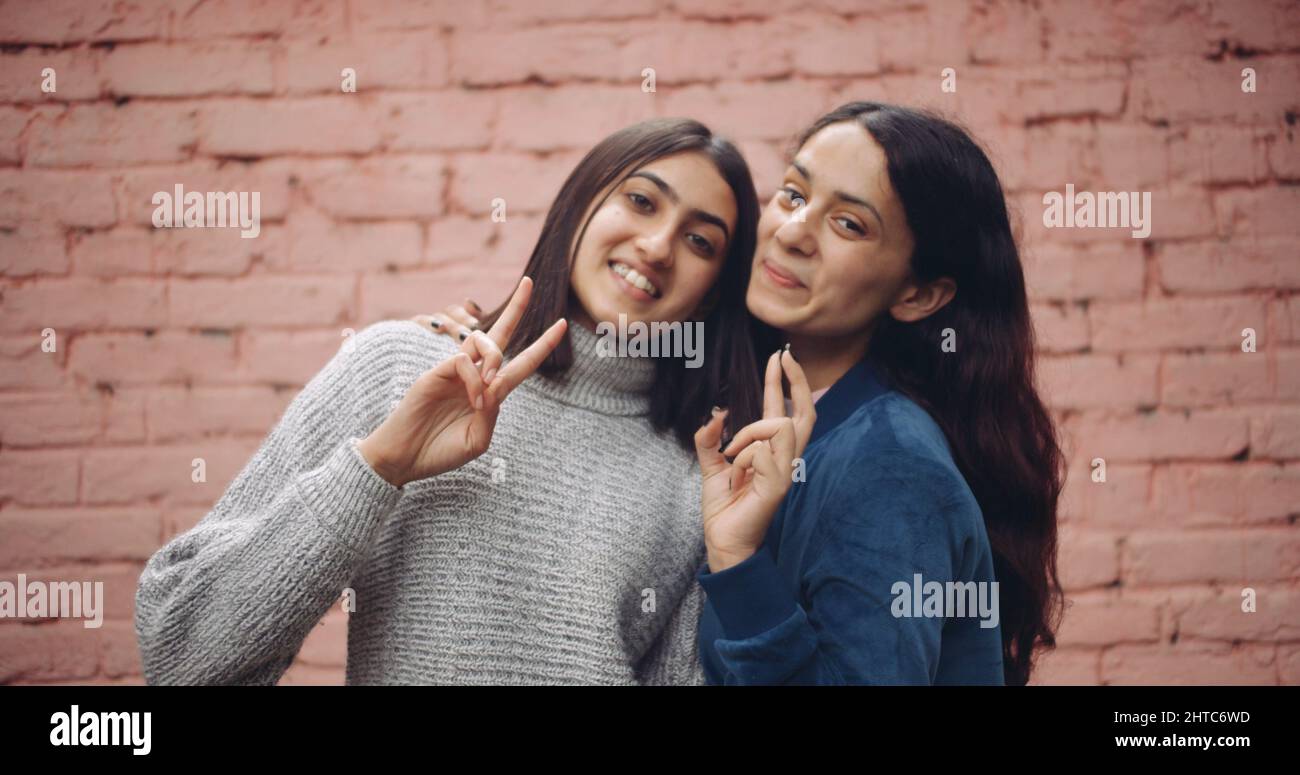 View of happy friends on the brick wall background smiling at the ...