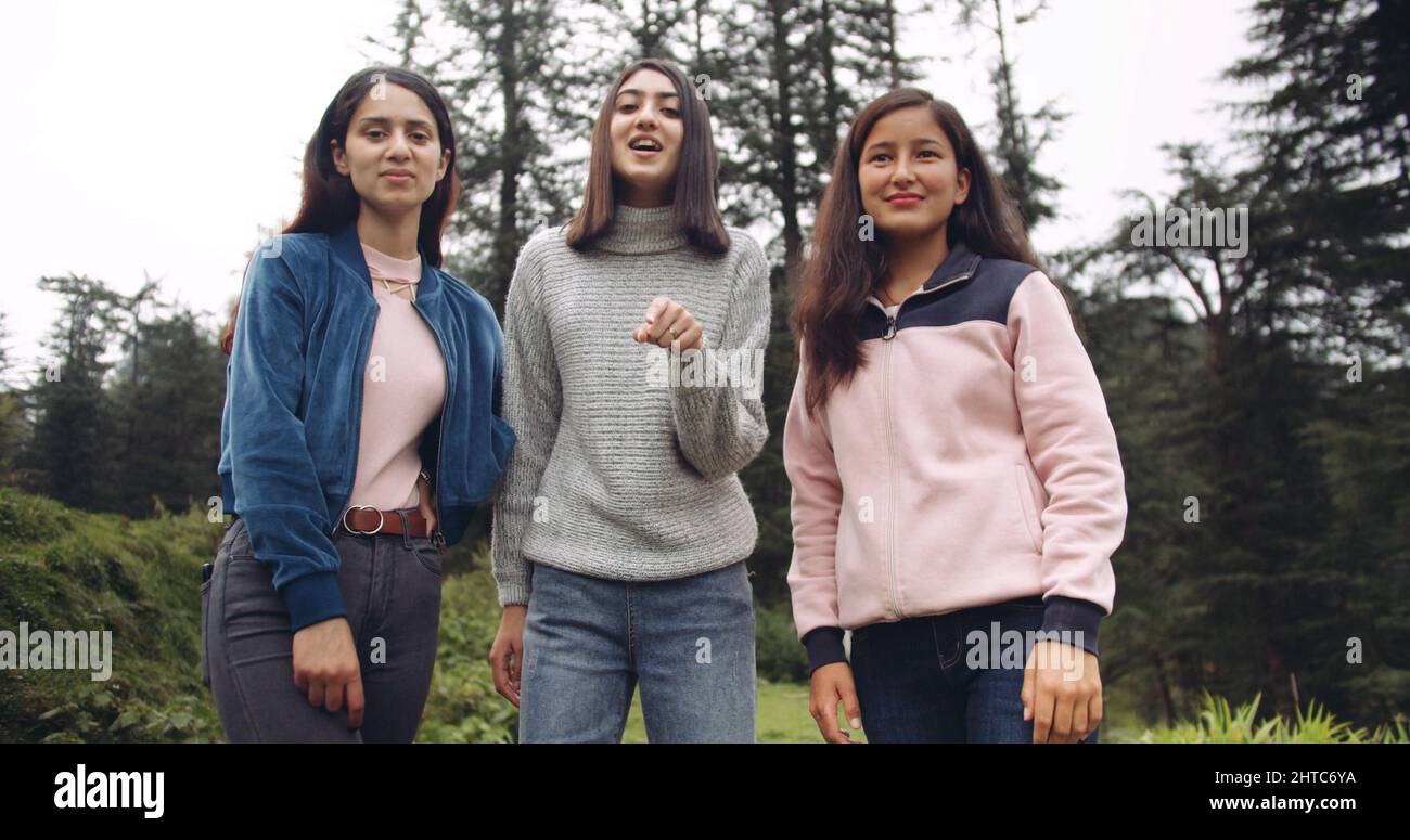 Young Indian girls pointing in front in a pine forest Stock Photo - Alamy