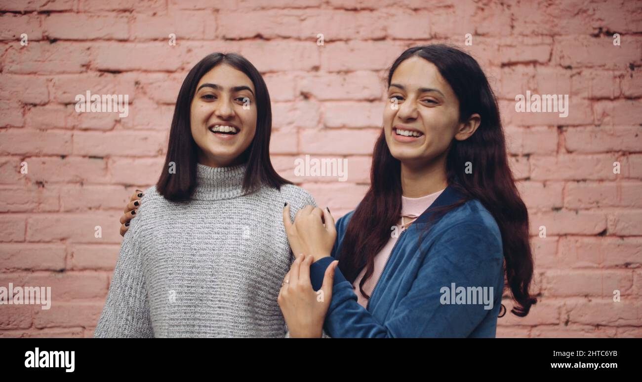 Indian happy friends smiling with a brick wall in the background Stock ...