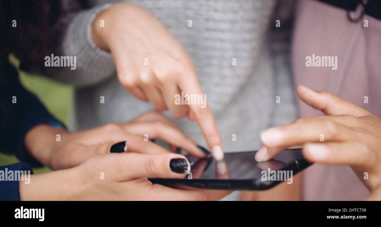 Group of young female South Asian friends touching a smartphone ...