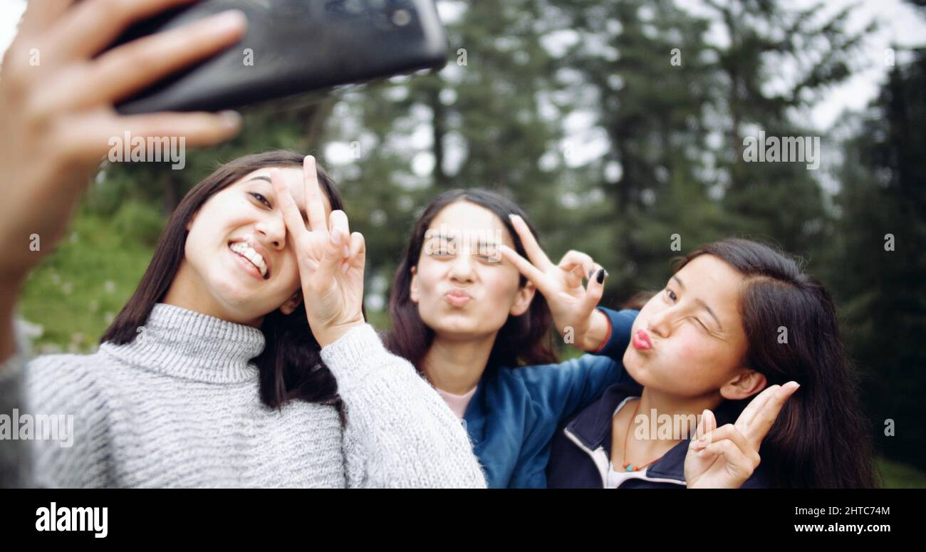 Friends taking fun selfies in the forest Stock Photo - Alamy