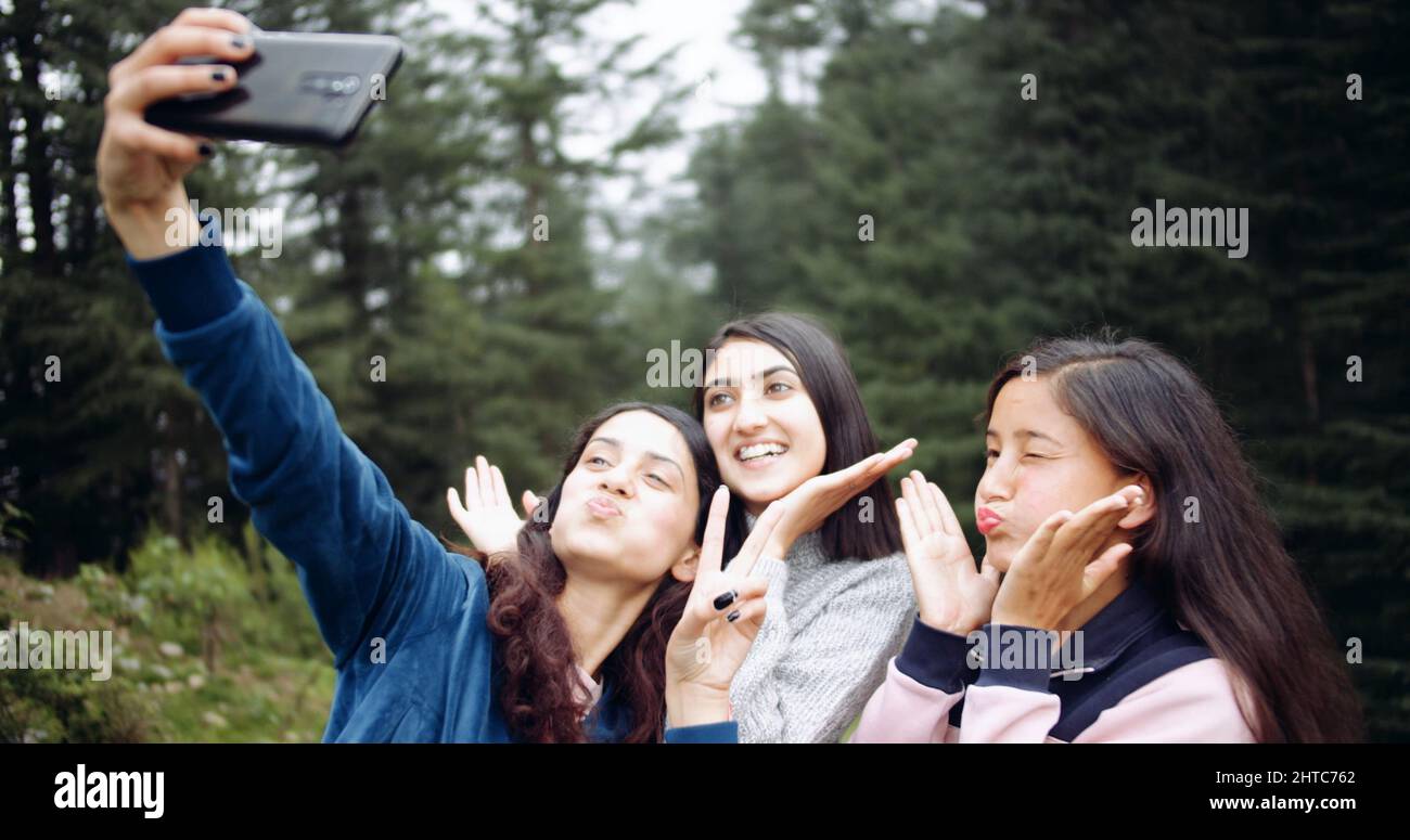 Friends taking fun selfies in the forest Stock Photo - Alamy