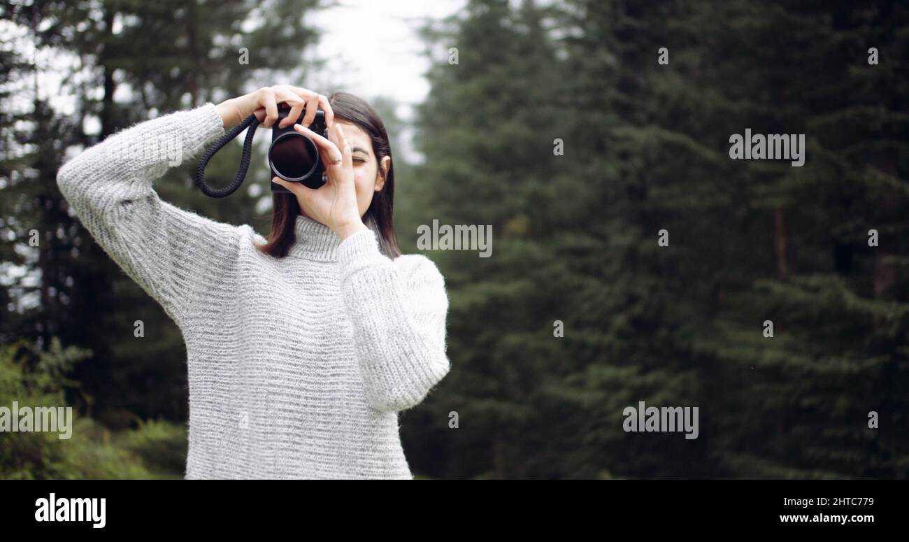 Indian woman taking photos with a camera in the forest Stock Photo - Alamy