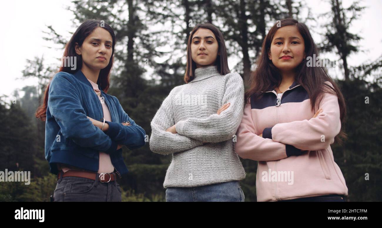 Young Indian girls standing in a pine forest with crossed arms Stock ...
