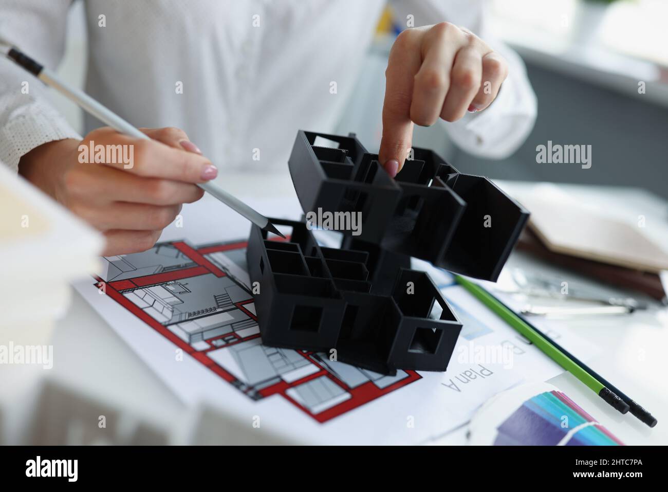 Female architect work on house project, use miniature house toy for ...
