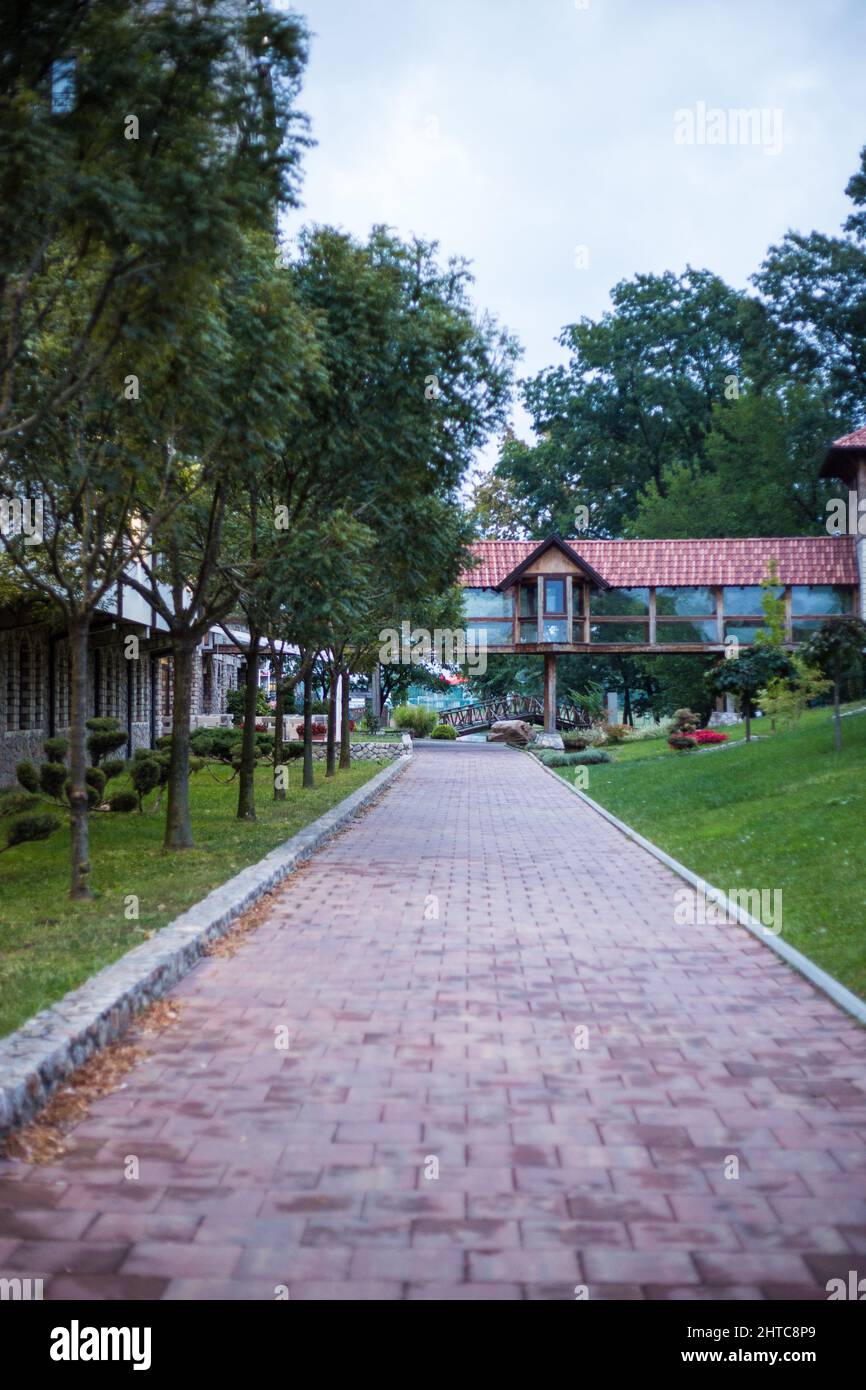 Beautiful view of a paved pathway surrounded by greens in a town Stock ...