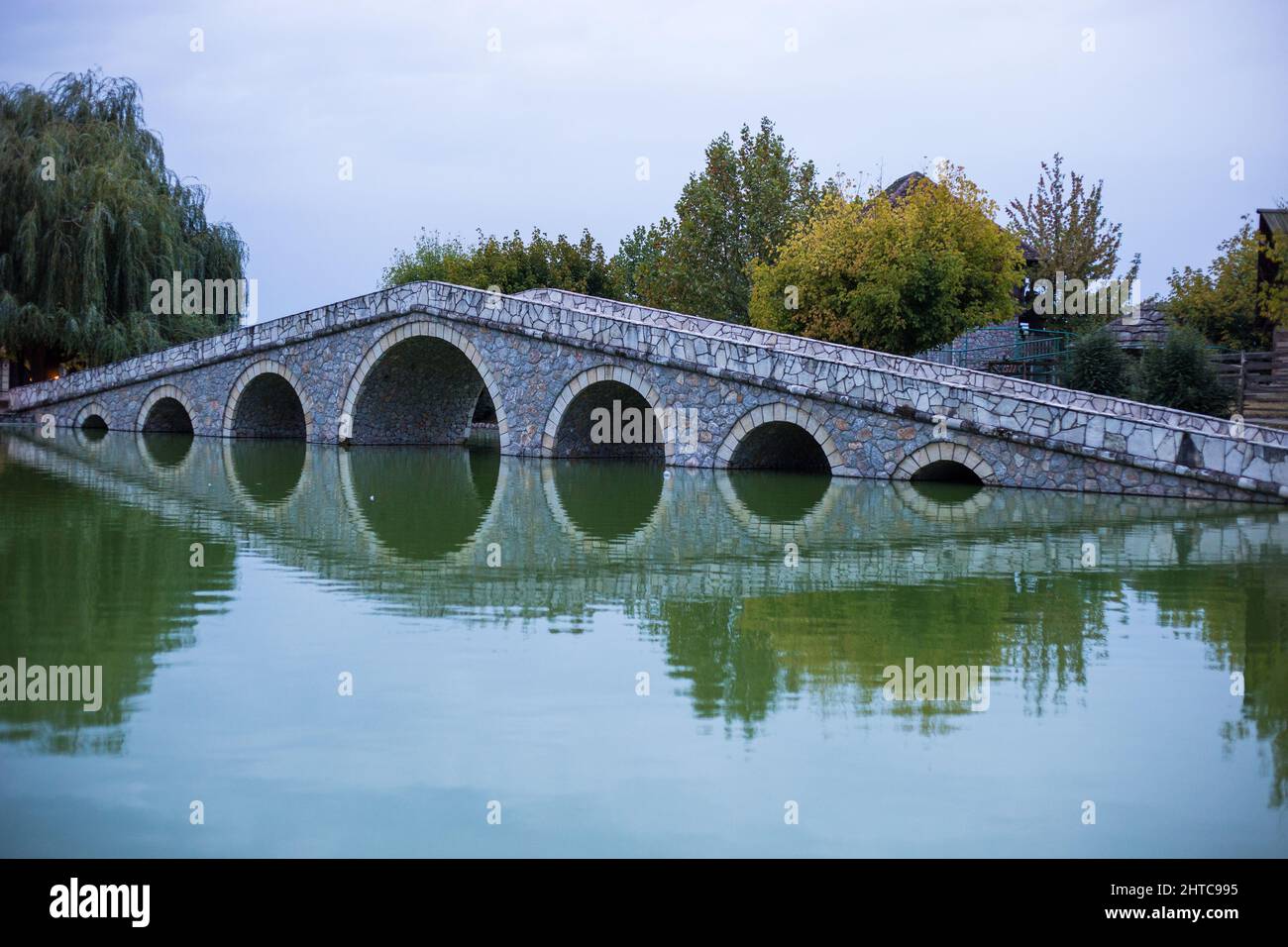 Beautiful stone bridge over the river in the village Stock Photo - Alamy