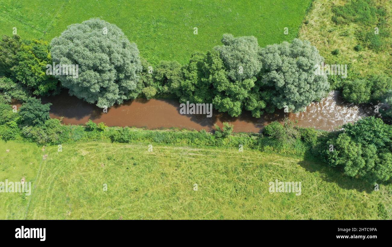 Top view of a dry dirty river that passes through an outdoor field ...