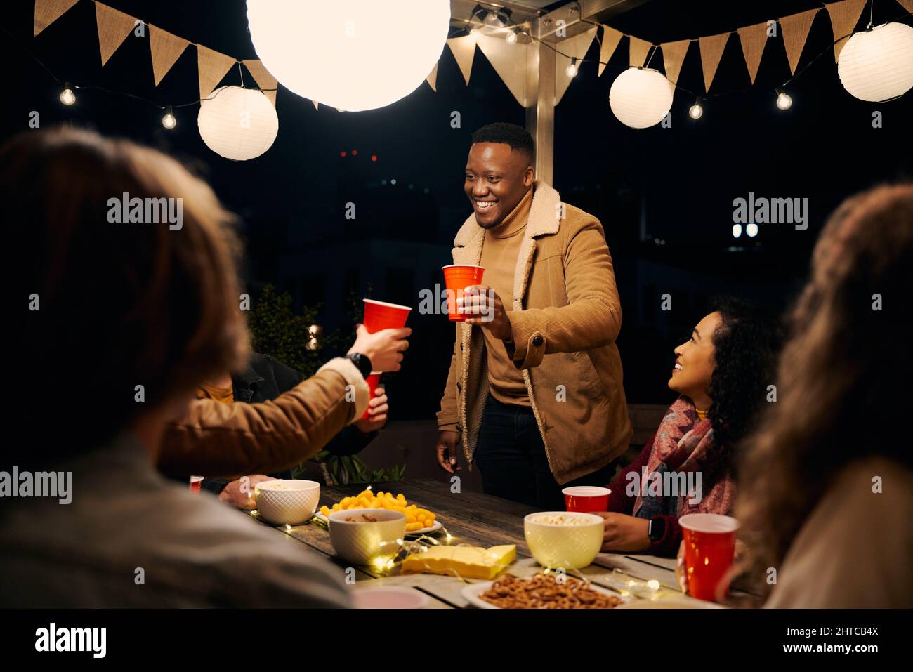 Black male standing, cheers with with group of diverse friends ...