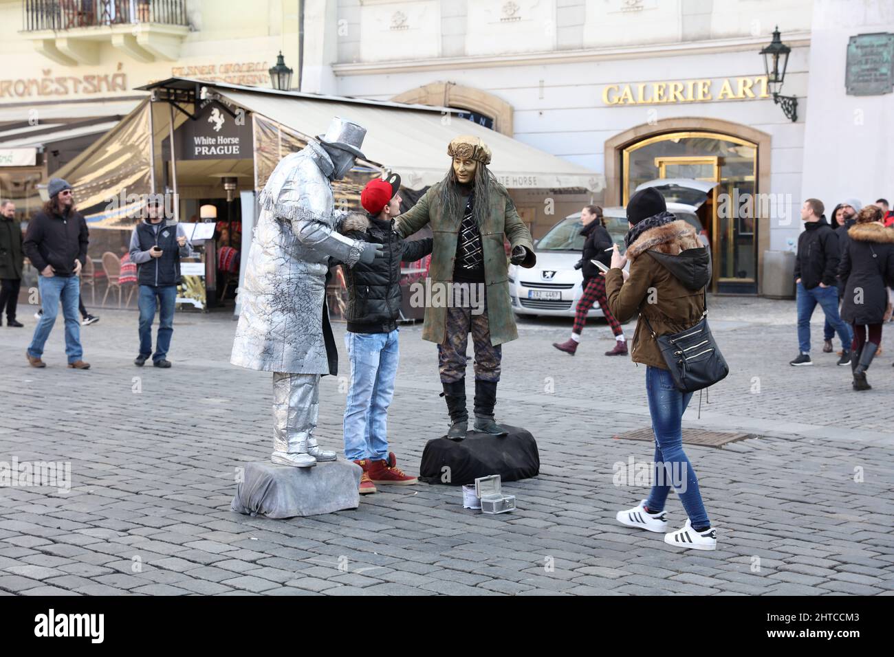 View of people taking photos with Silver painted street performers in ...