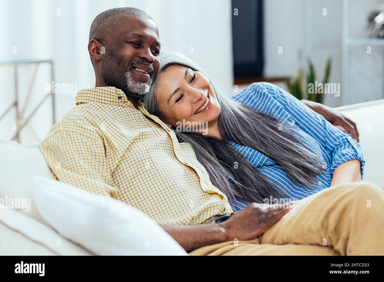 Cinematic image of an happy multiethnic senior couple. Indoors ...