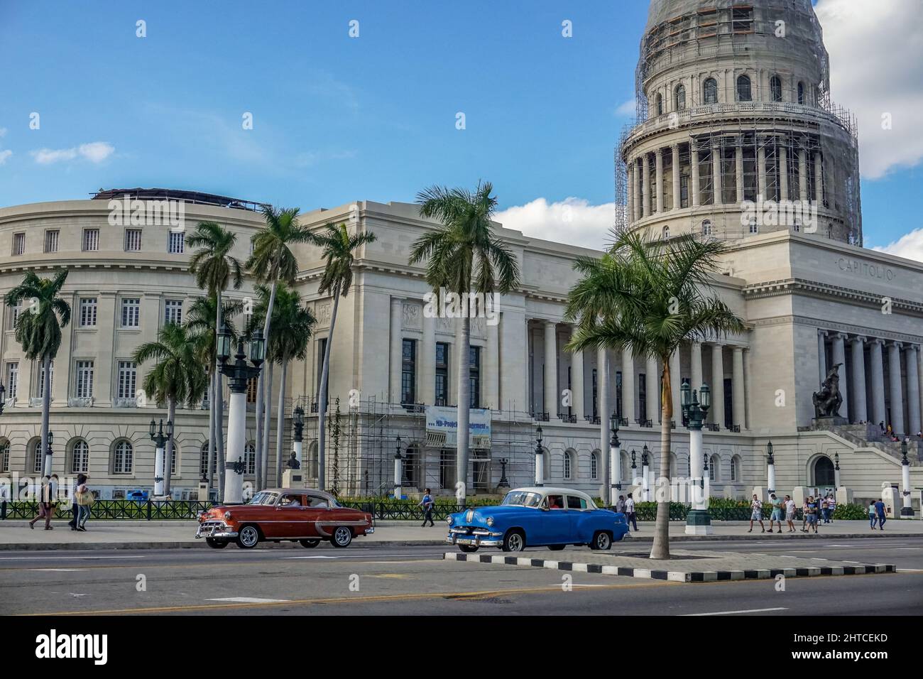 National Capitol Building in Havana, and blue and red classic cars on ...