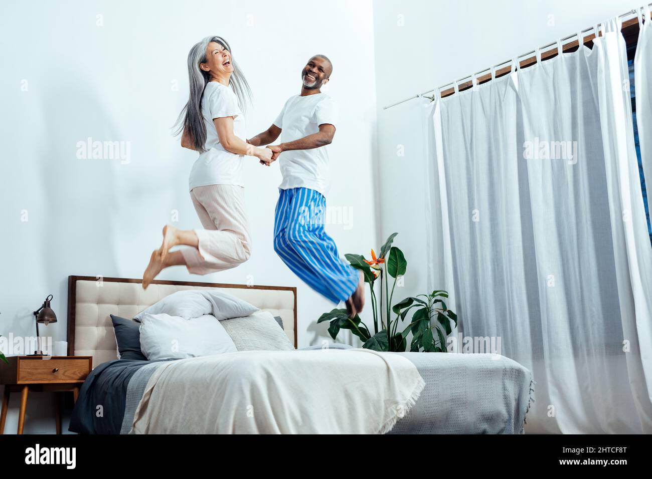Cinematic image of an happy multiethnic senior couple. Indoors ...