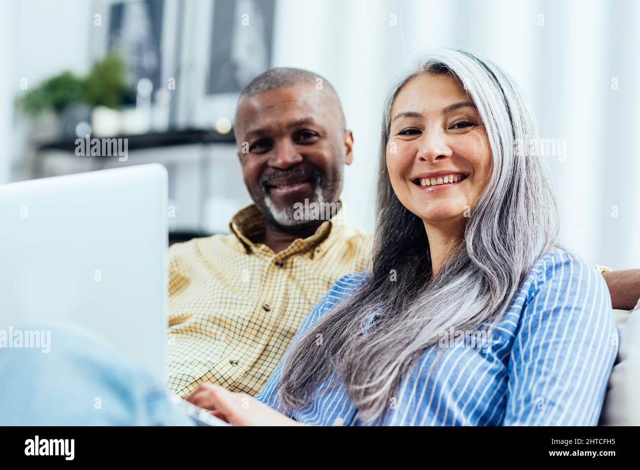 Cinematic image of an happy multiethnic senior couple. Indoors ...