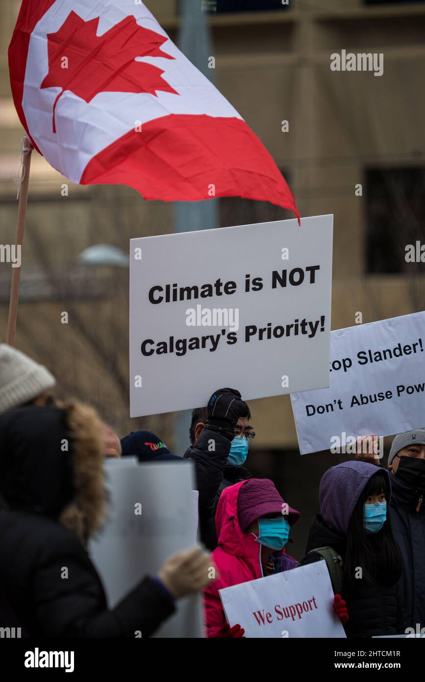 Vertical shot of protestors waving Canadian Flag and posters with texts ...