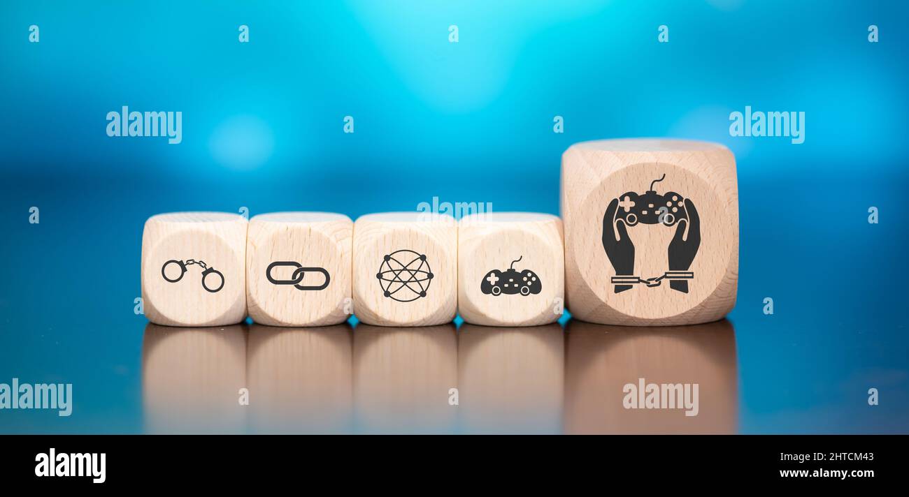Wooden blocks with symbol of video game addiction concept on blue ...