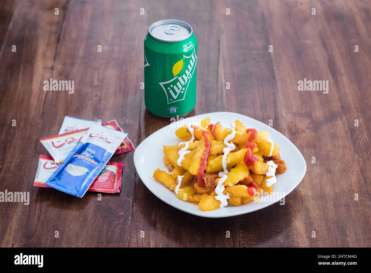 Plate of french fries with Sprite on wooden table Stock Photo - Alamy