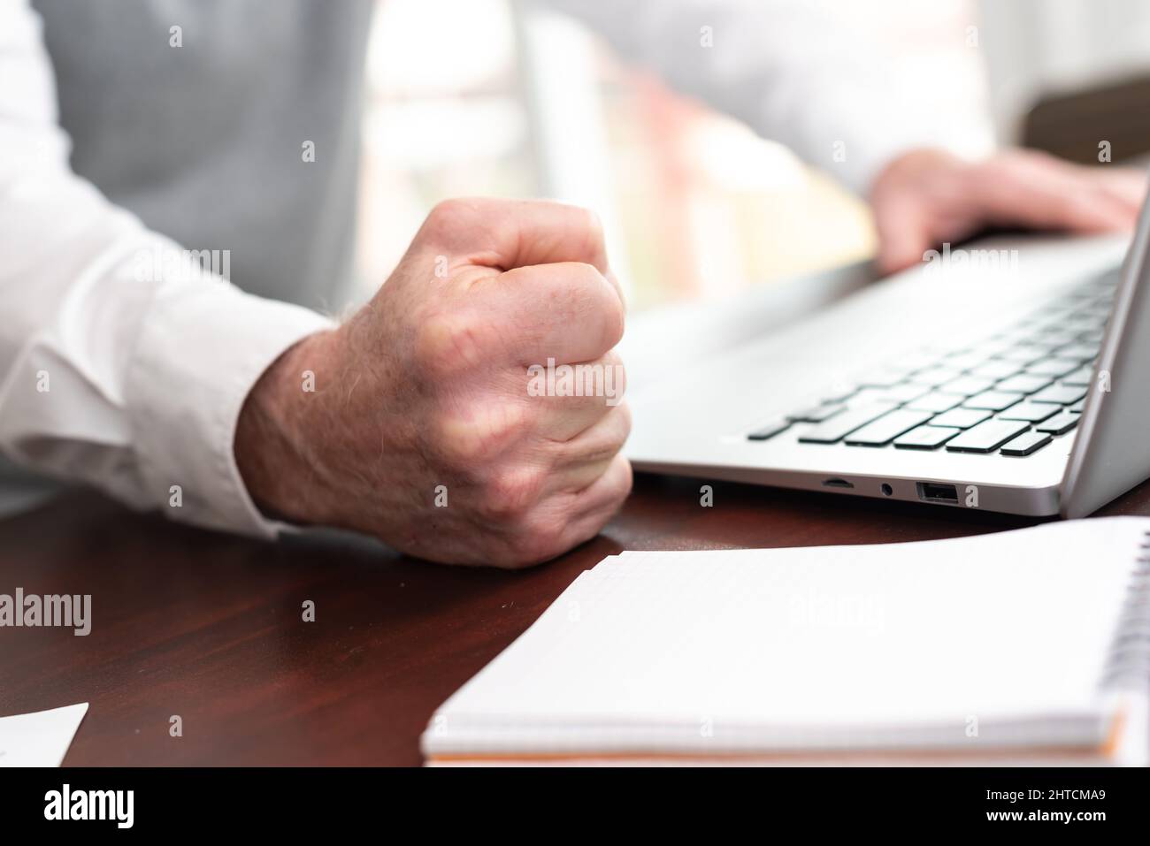 Angry businessman hitting his desk with his clenched fist Stock Photo ...