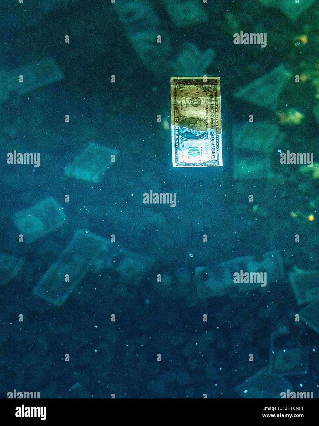 One dollar bill floating in water with more coins and money underneath ...