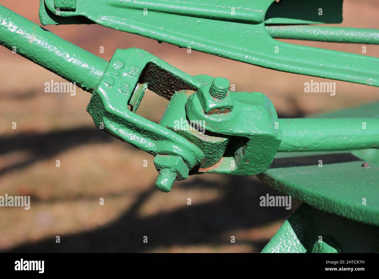 A rotating nut and bolt steel connection on an old tractor machine ...