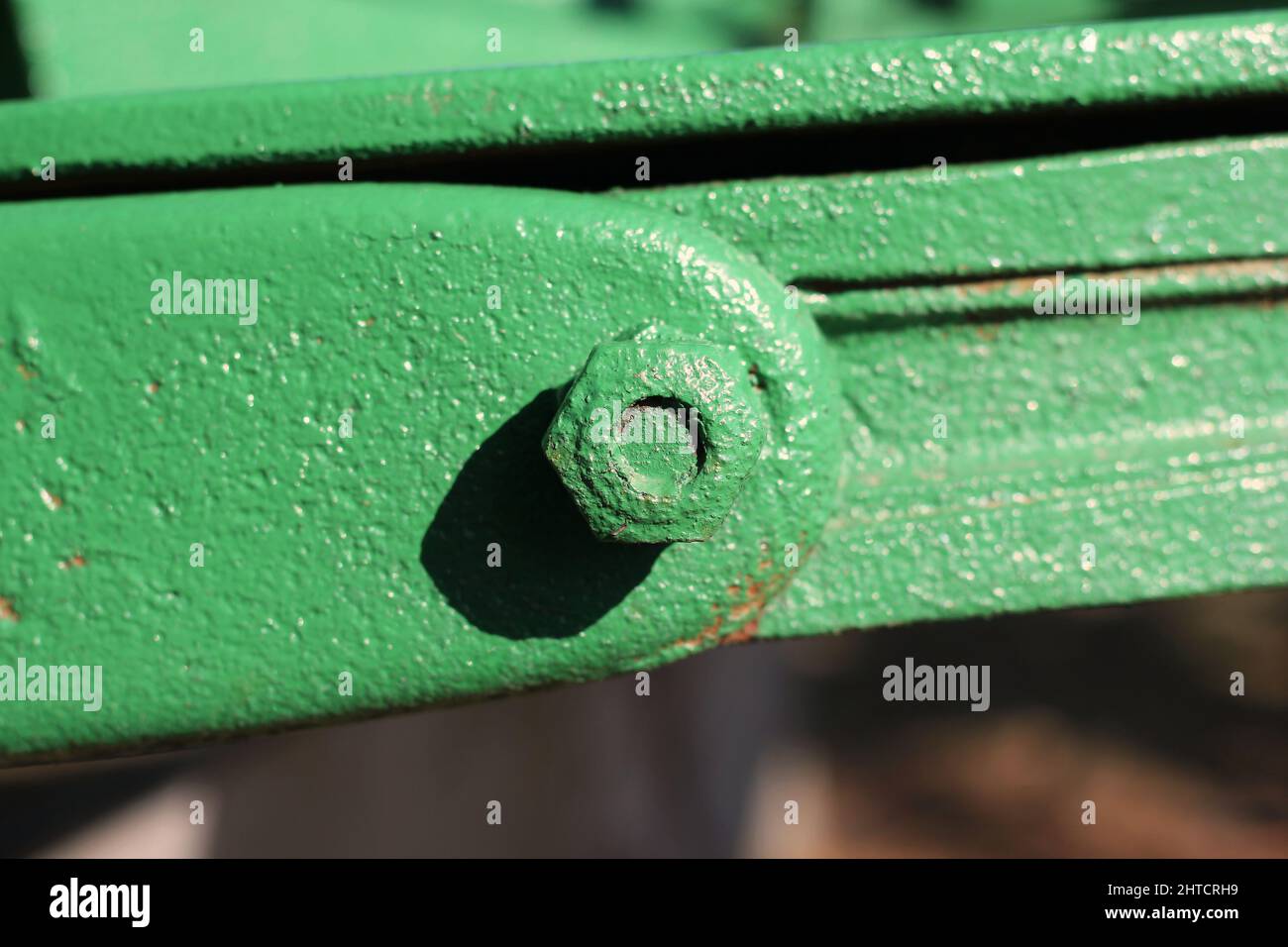 A rotating nut and bolt steel connection on an old tractor machine ...