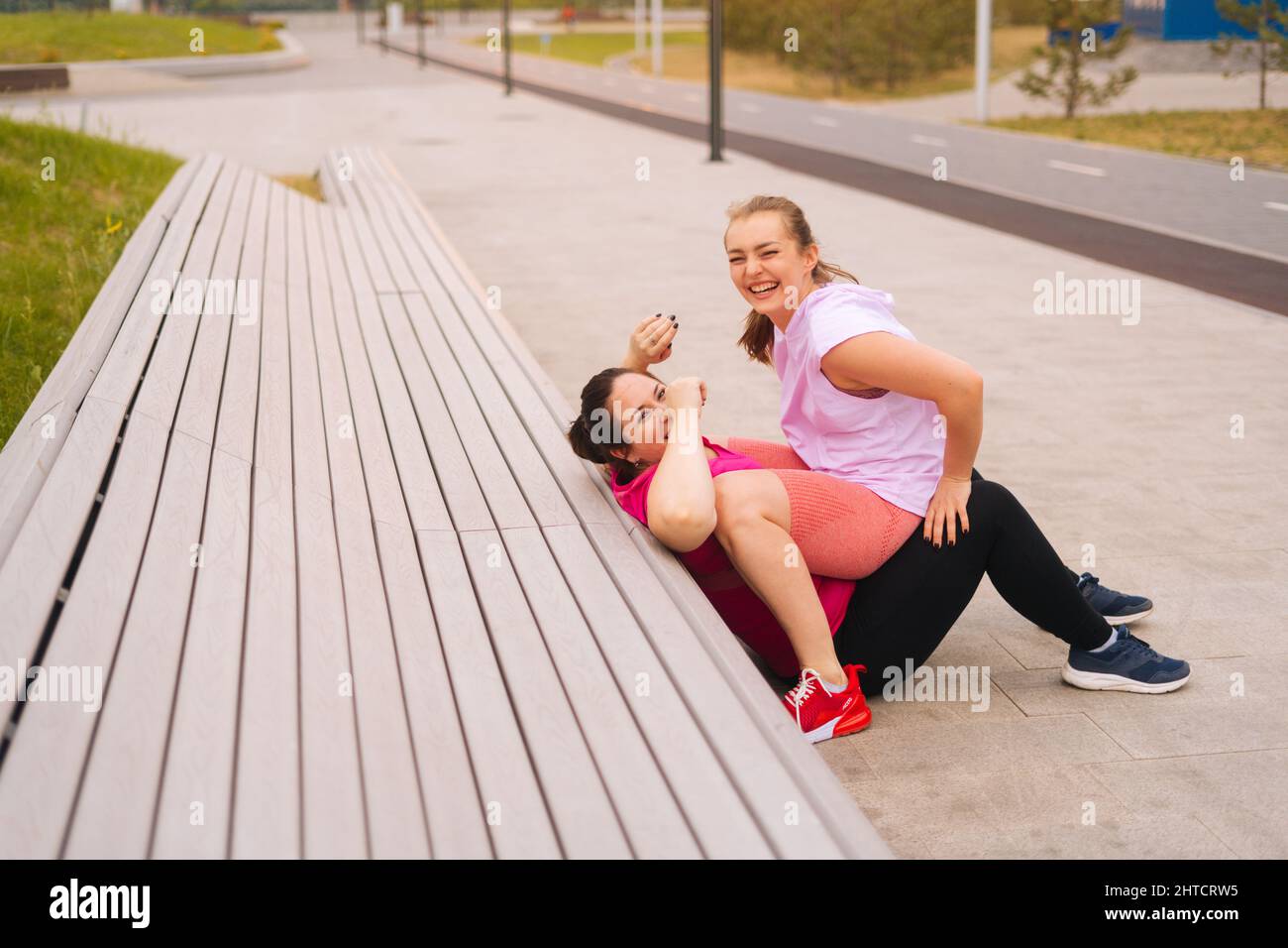Laughing fat young woman training with cheerful fitness instructor ...
