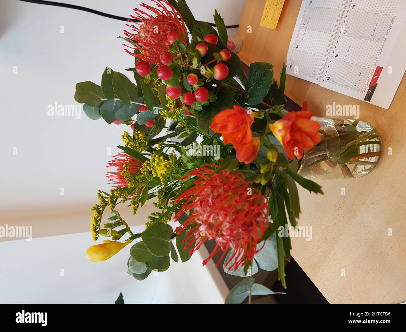 Vertical shot of the beautiful red bouquet and desk calendar on the ...
