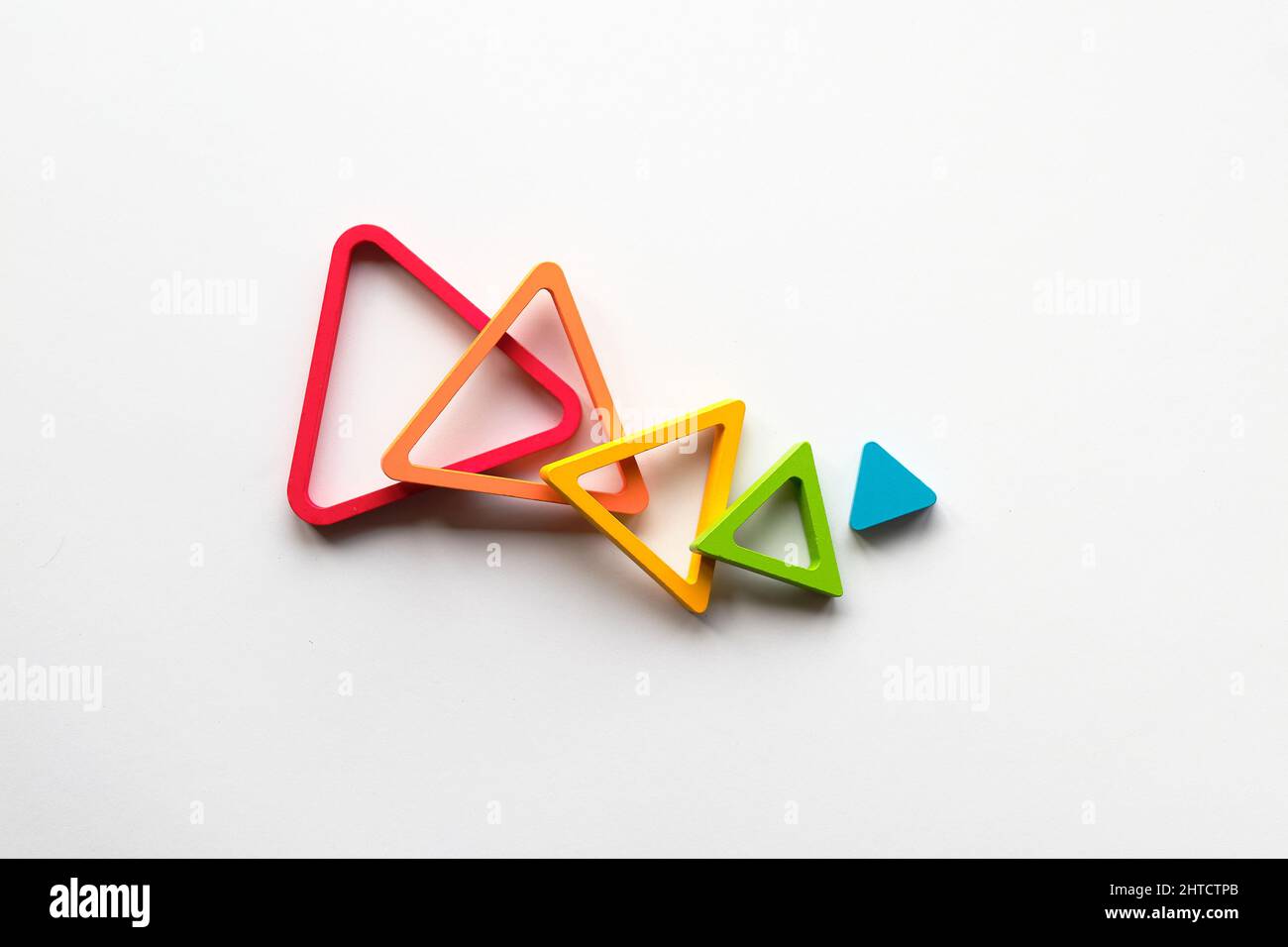 Nested wooden triangles painted in rainbow colors. Flat lay on white paper background Stock ...
