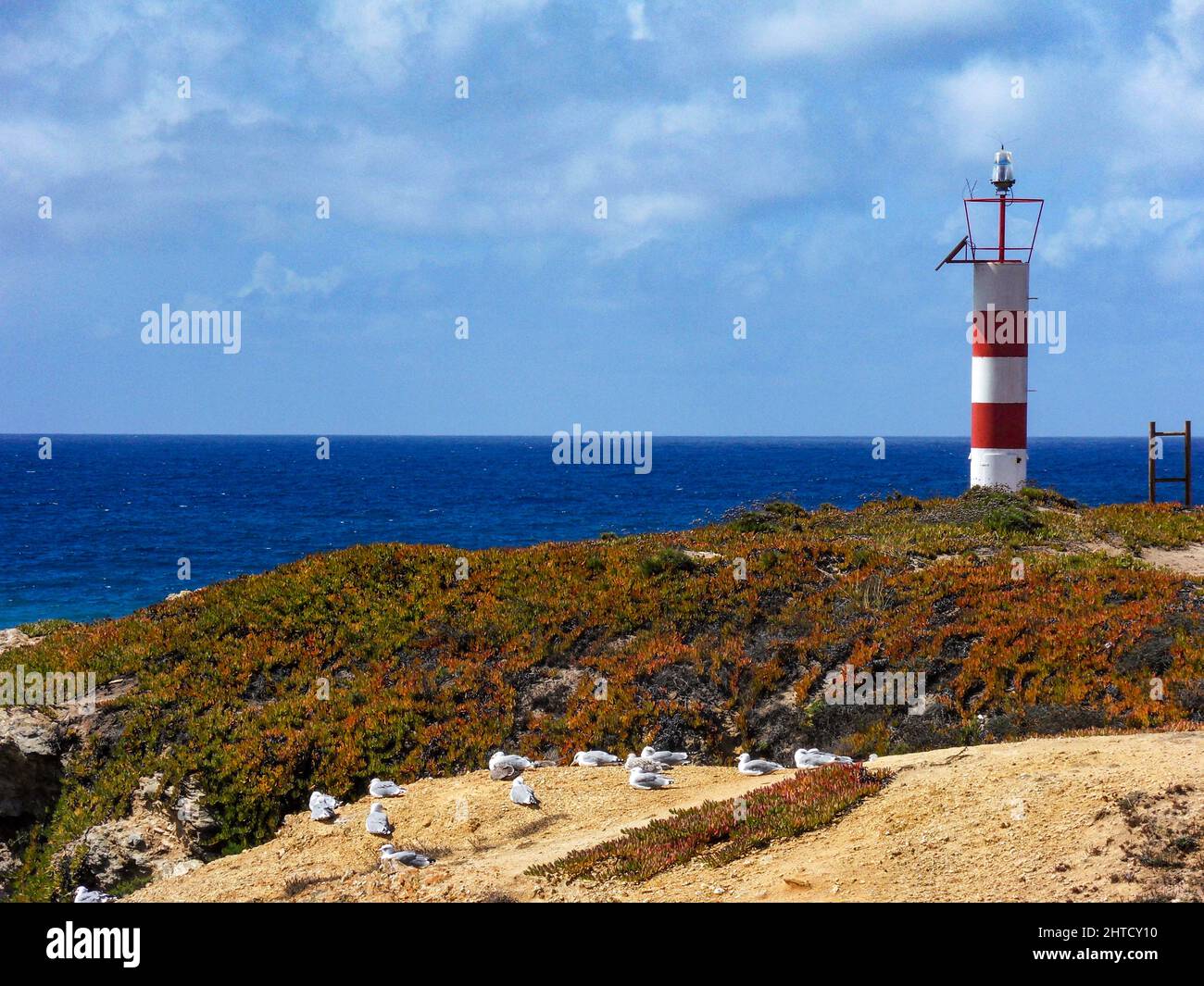 Old lighthouse on the coast of Alentejo Litoral in Portugal under a ...