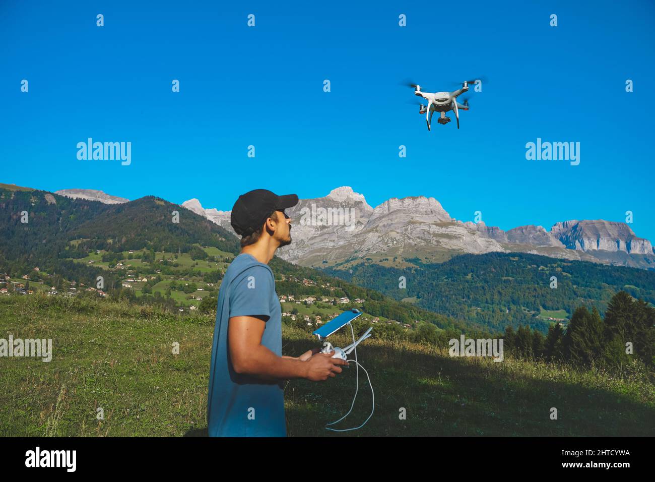 Young man flying drone on amazing mountain landscape. Man operating a ...