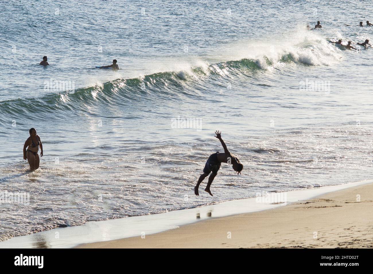 Young man does a somersault on the sands of Paciencia beach in Rio ...