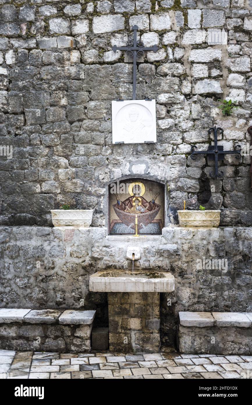 Vertical shot of medieval Orthodox monument with built stone tap and ...