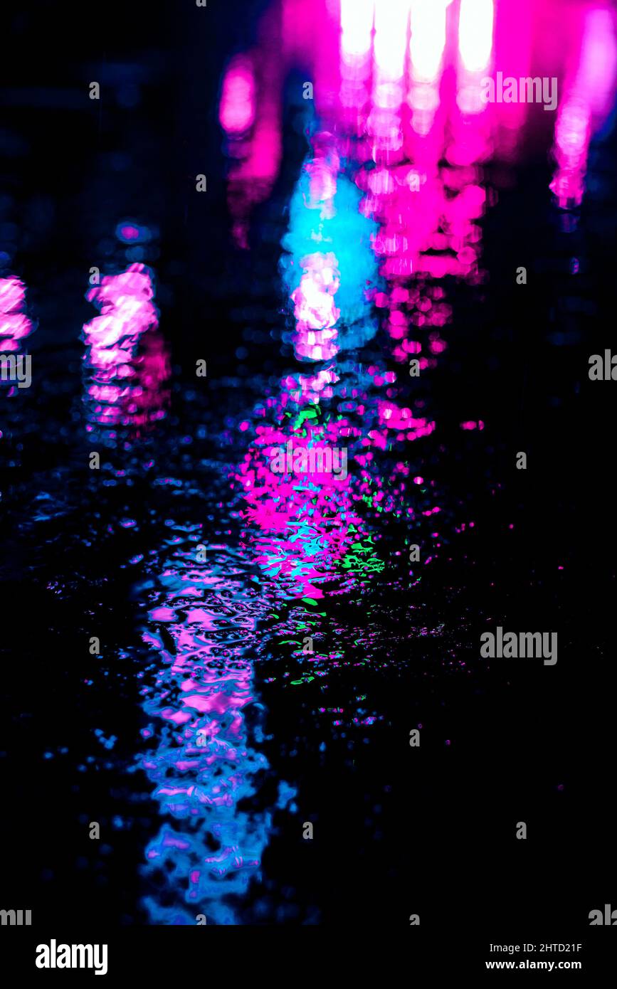 Vertical shot of neon lights reflecting on the wet rainy ground Stock ...