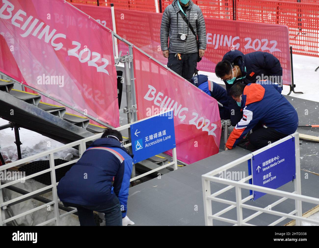 Beijing, China. 28th Feb, 2022. Staff members fix the barrier-free ...