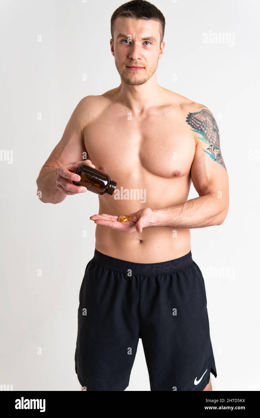 Fish oil is eaten by a man in the hands of vials and a glass bottle ...