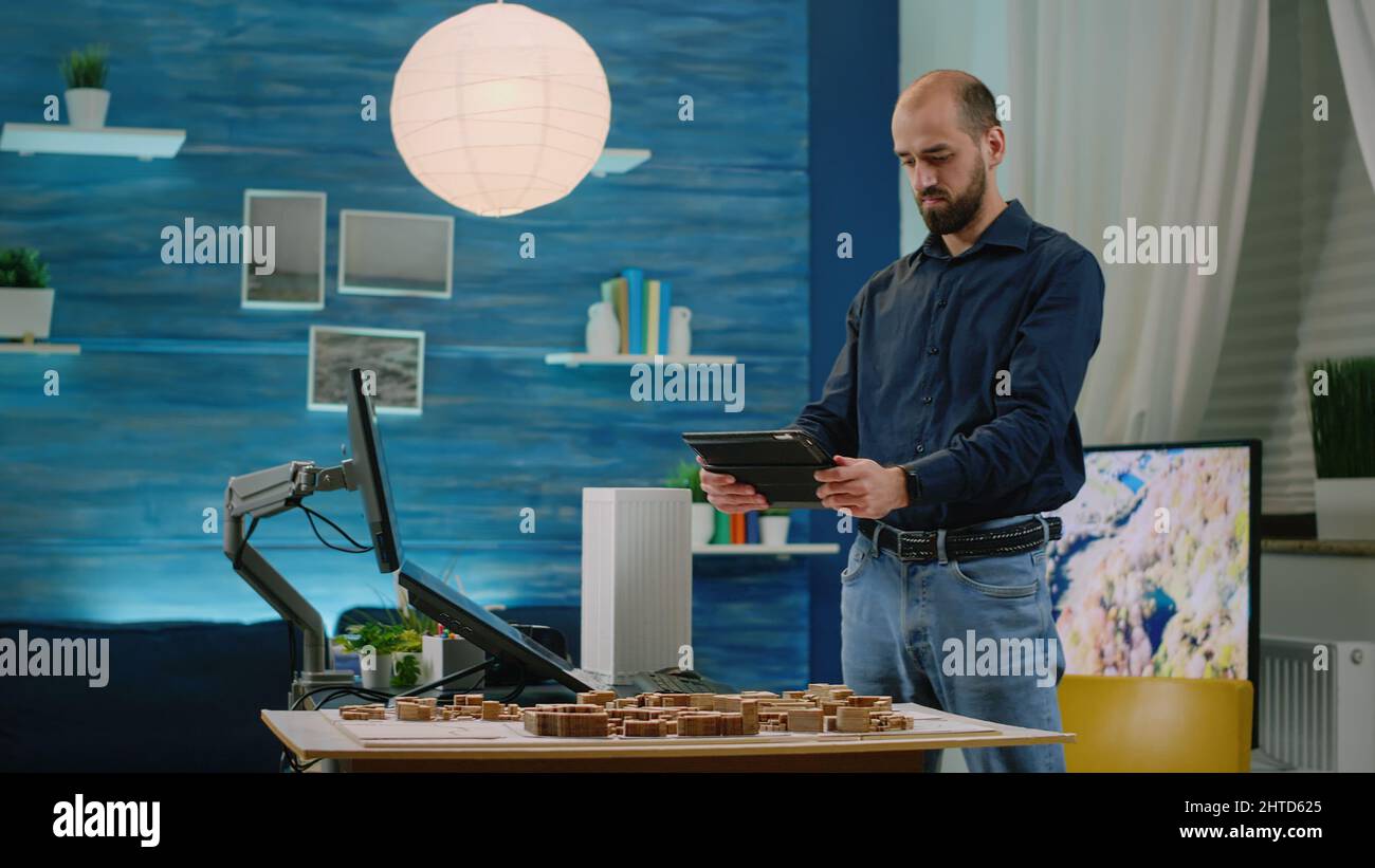 Man Architect Holding Tablet With Building Model Analyzing Computer For Construction Development