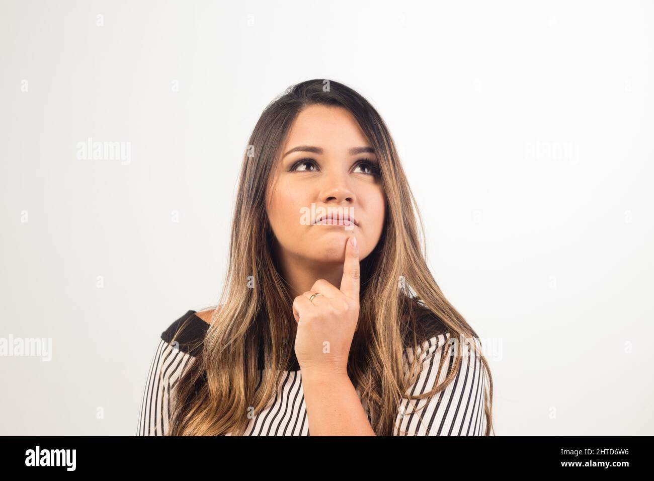 White latina girl thinking on the white background Stock Photo - Alamy