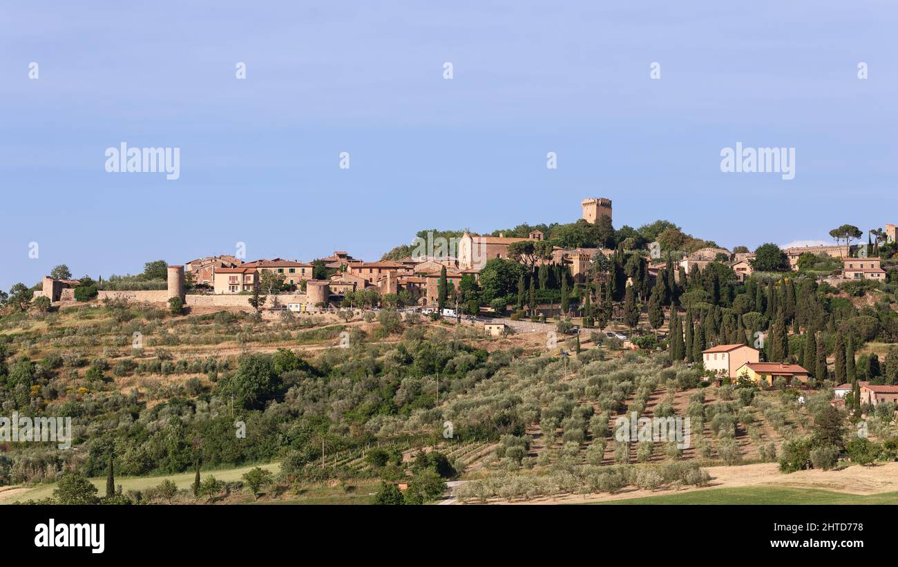 View to the remains of old Monticchiello town walls, church, cypresses ...