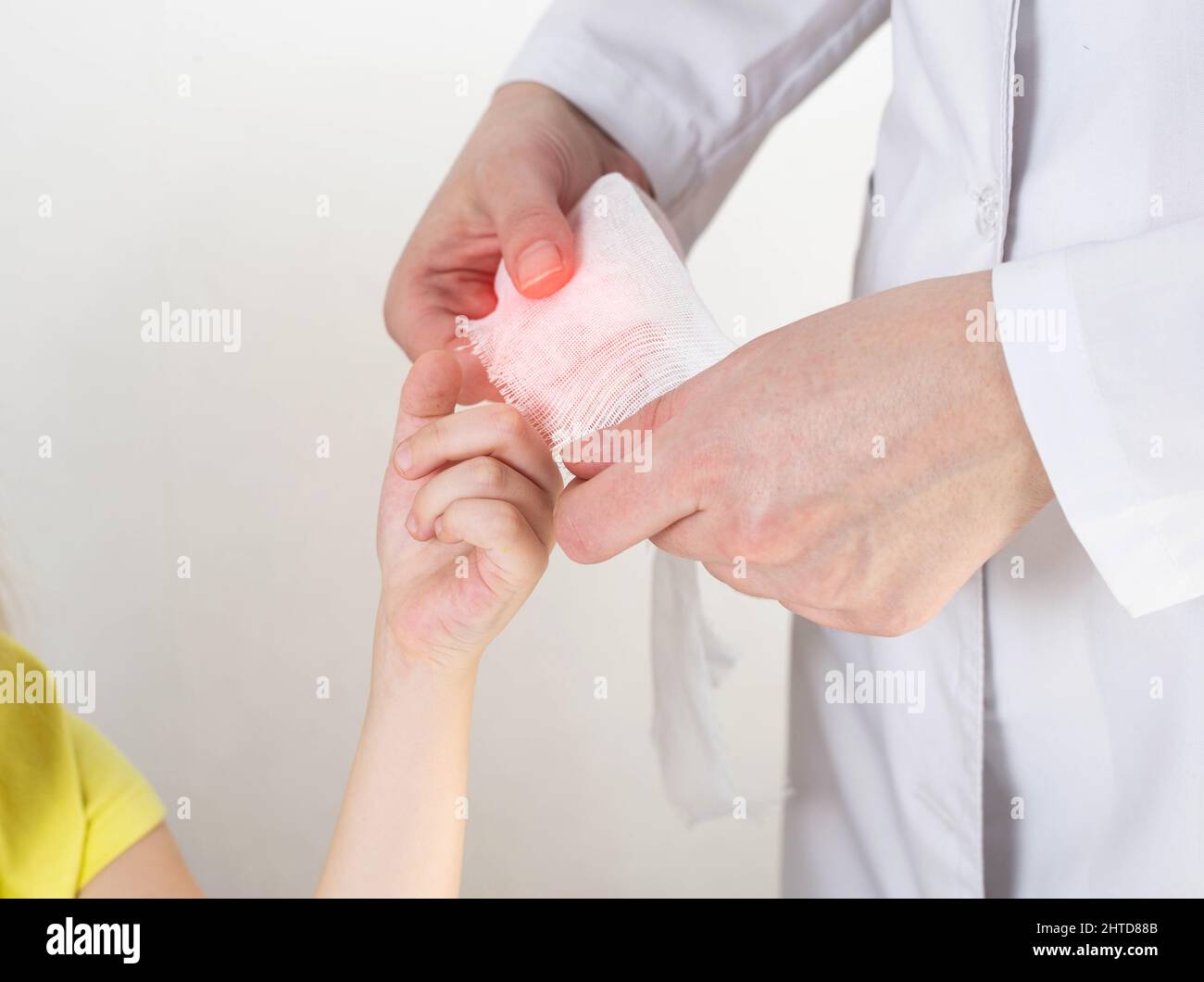 The hands of the doctor bandage the sore finger with a bandage of the ...