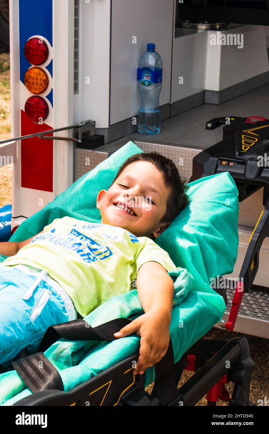 Young boy laying in a carrier of an ambulance during a fire department ...